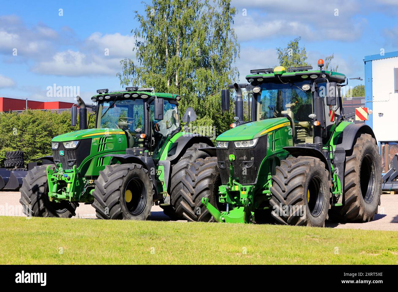 John Deere 6215R and John Deere 7310R farm tractors parked on asphalt ...