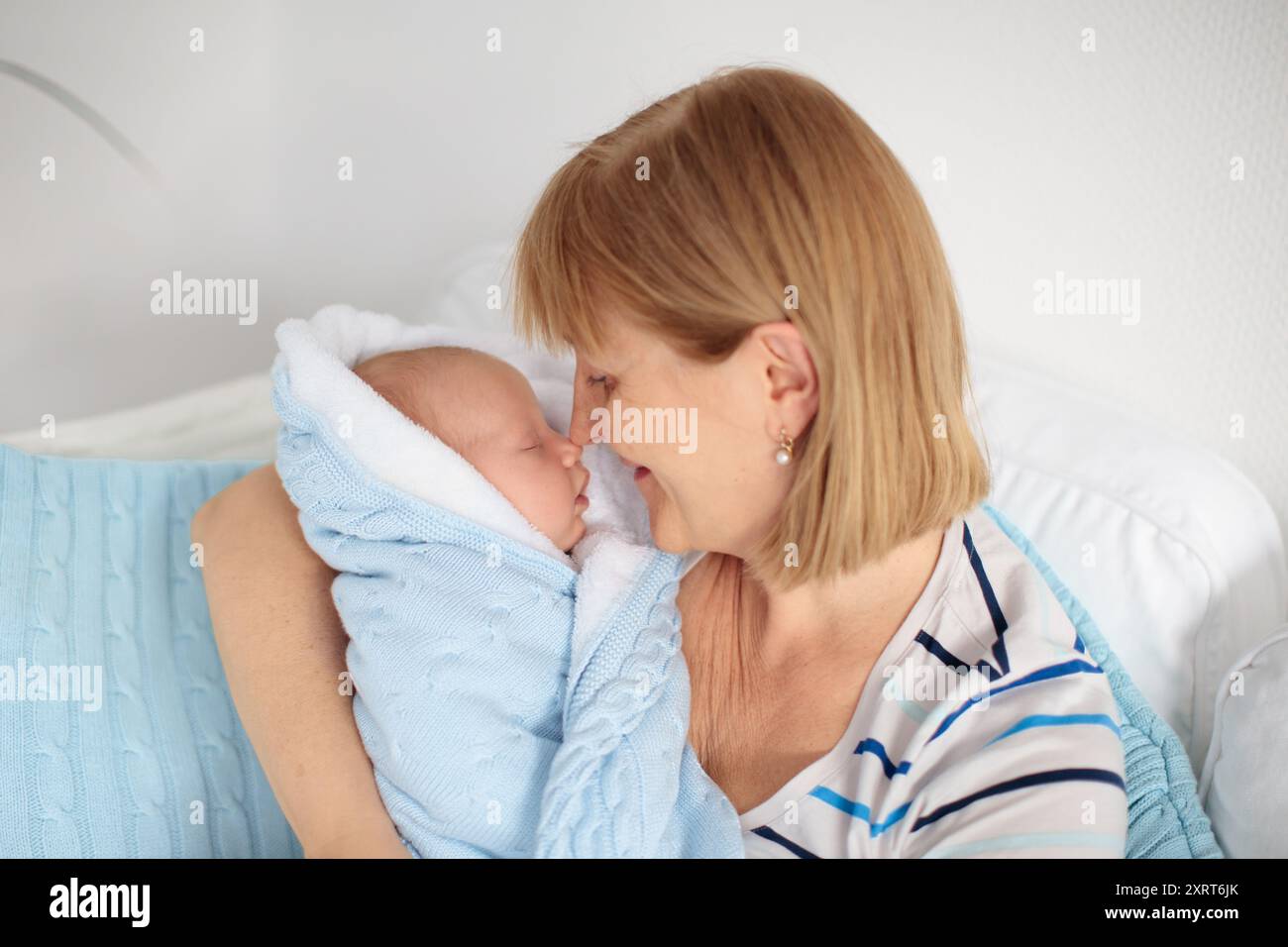 Grandmother holding newborn baby. Grandma meeting new family member ...