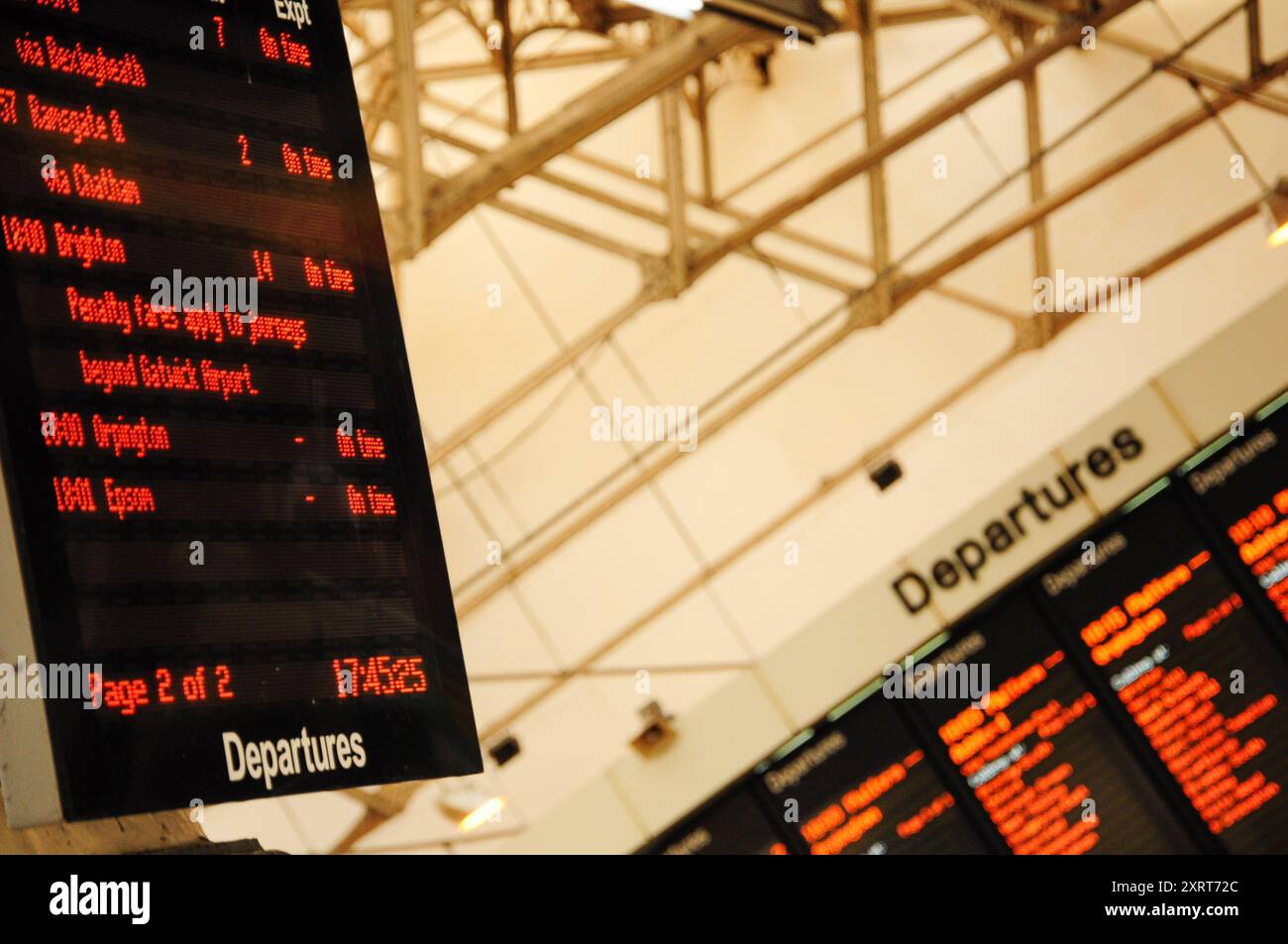Train departure boards in busy station displaying schedules in bright ...