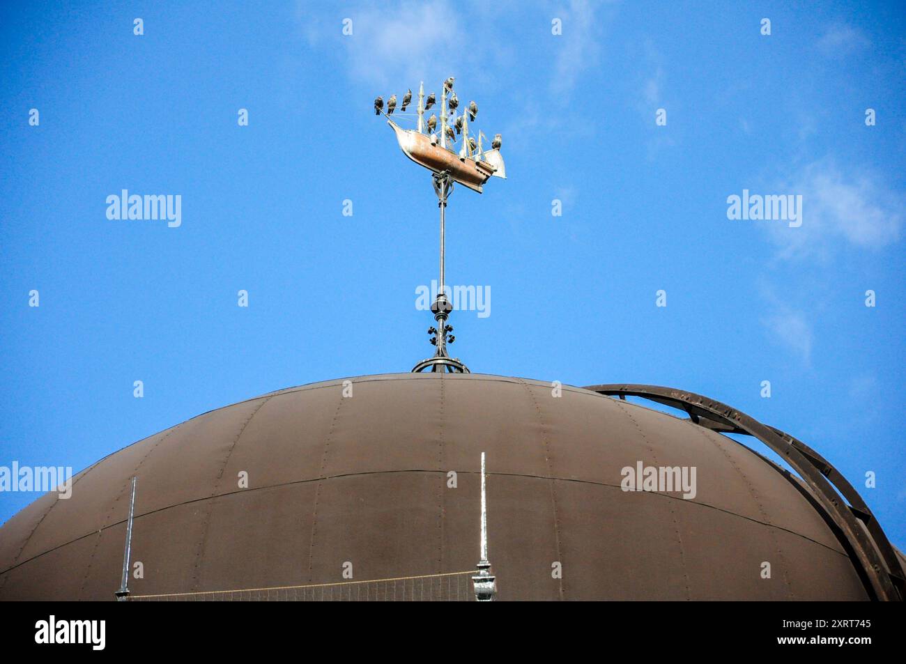 Sculpture of a ship atop a dome against a clear blue sky in London ...