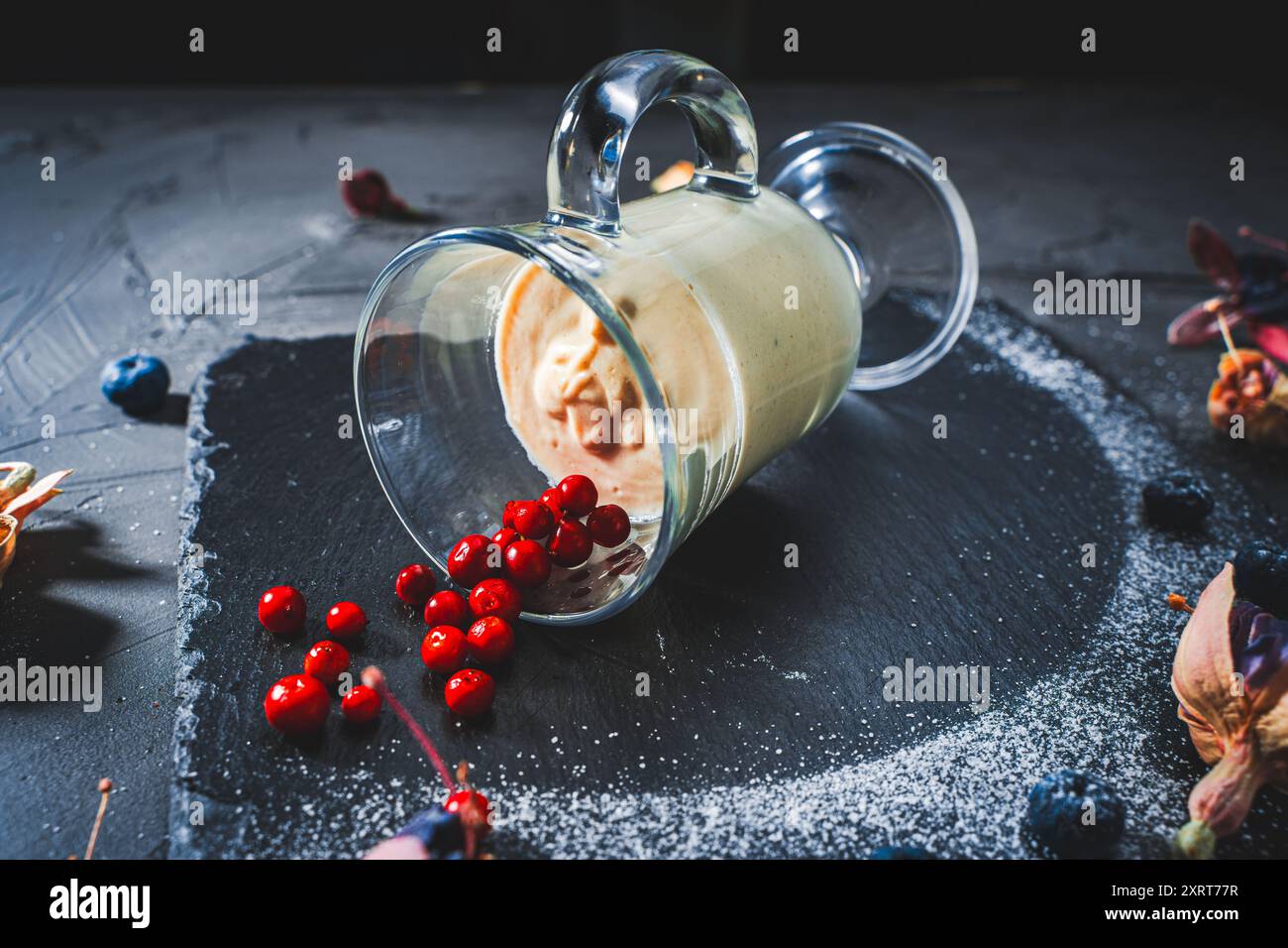 Panna cotta in a transparent glass lying on a black mica board with ...