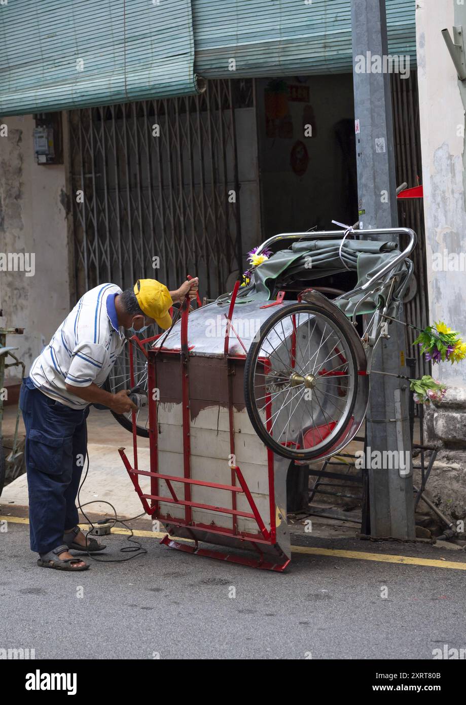 Mechanic repairing a rickshaw in the street, Penang island, George Town ...