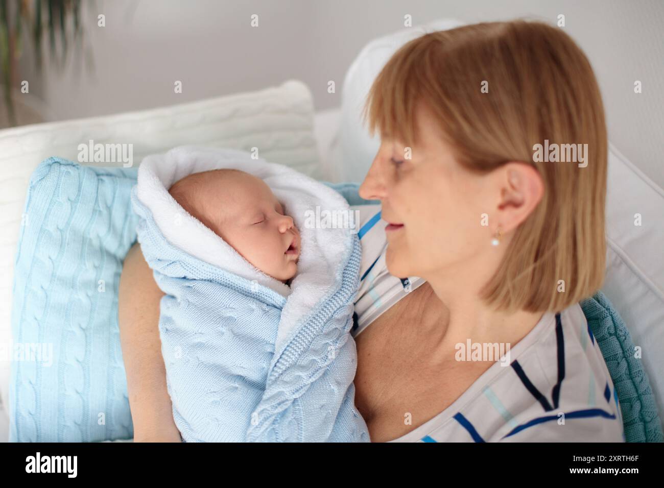 Grandmother holding newborn baby. Grandma meeting new family member ...