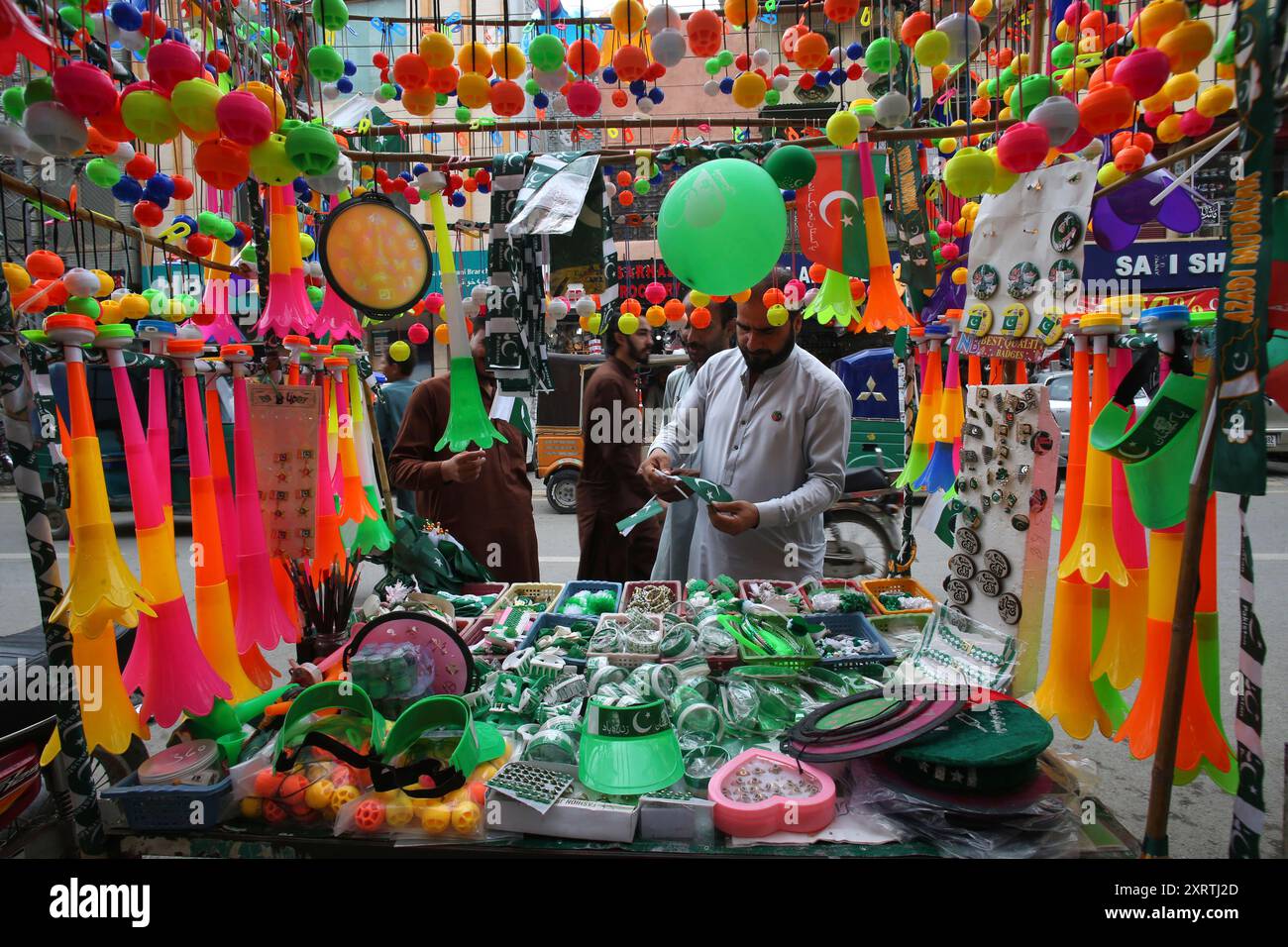A man buys a national flag in Peshawar, Pakistan, Monday, Aug. 12, 2024 ...