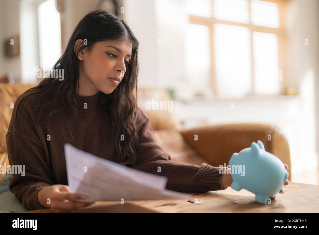 Worried young indian woman reading letter savings employment tax paying ...
