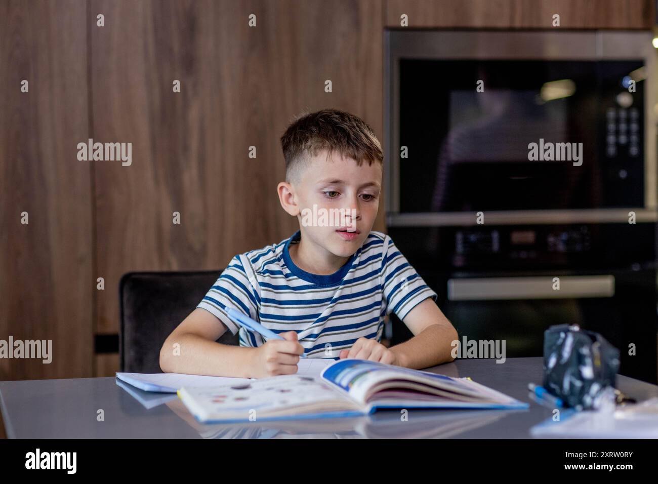 Boy in kitchen doing homework hi-res stock photography and images - Alamy