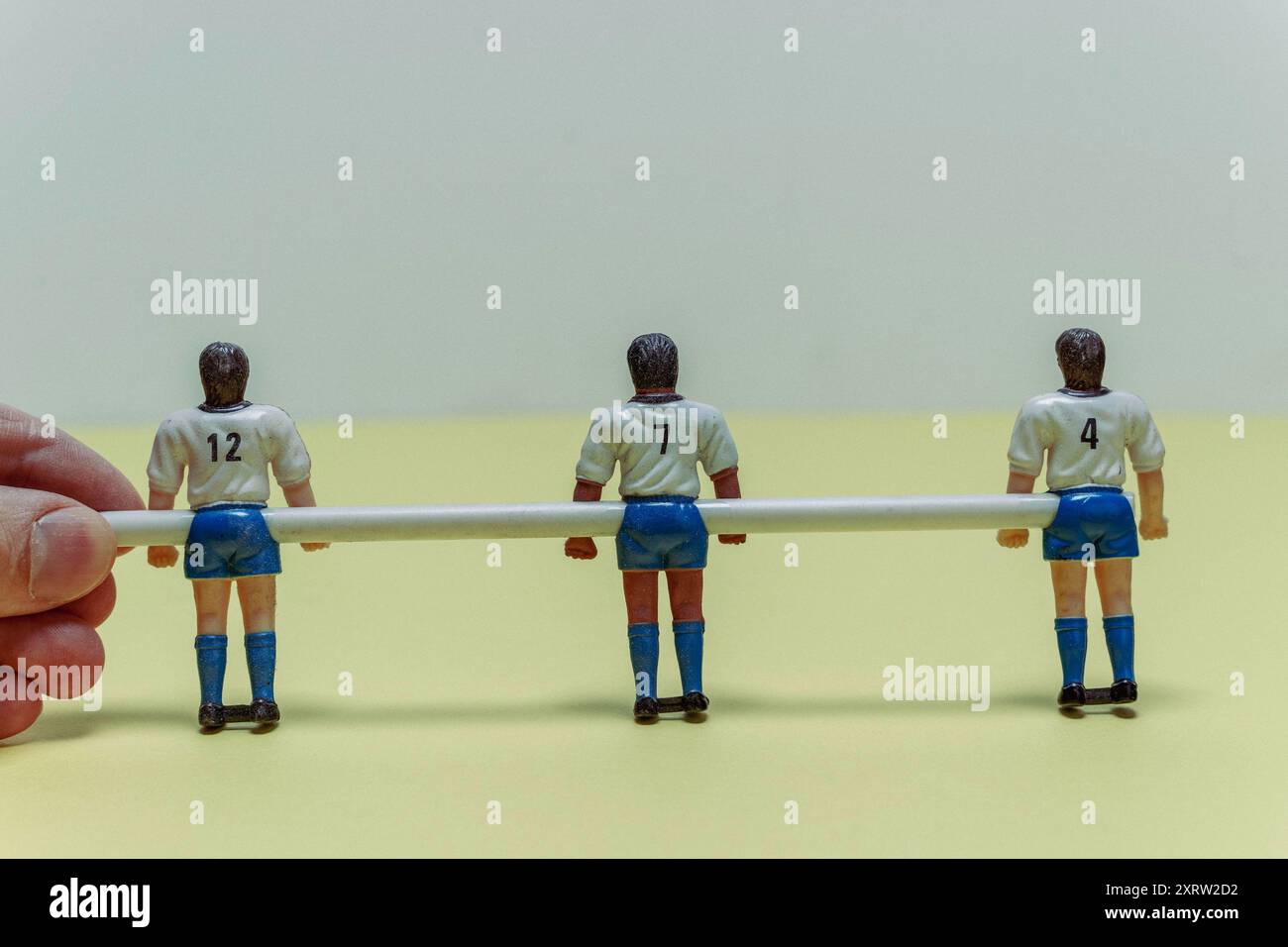 football players, rear view. the hand holds a detailed mini football ...