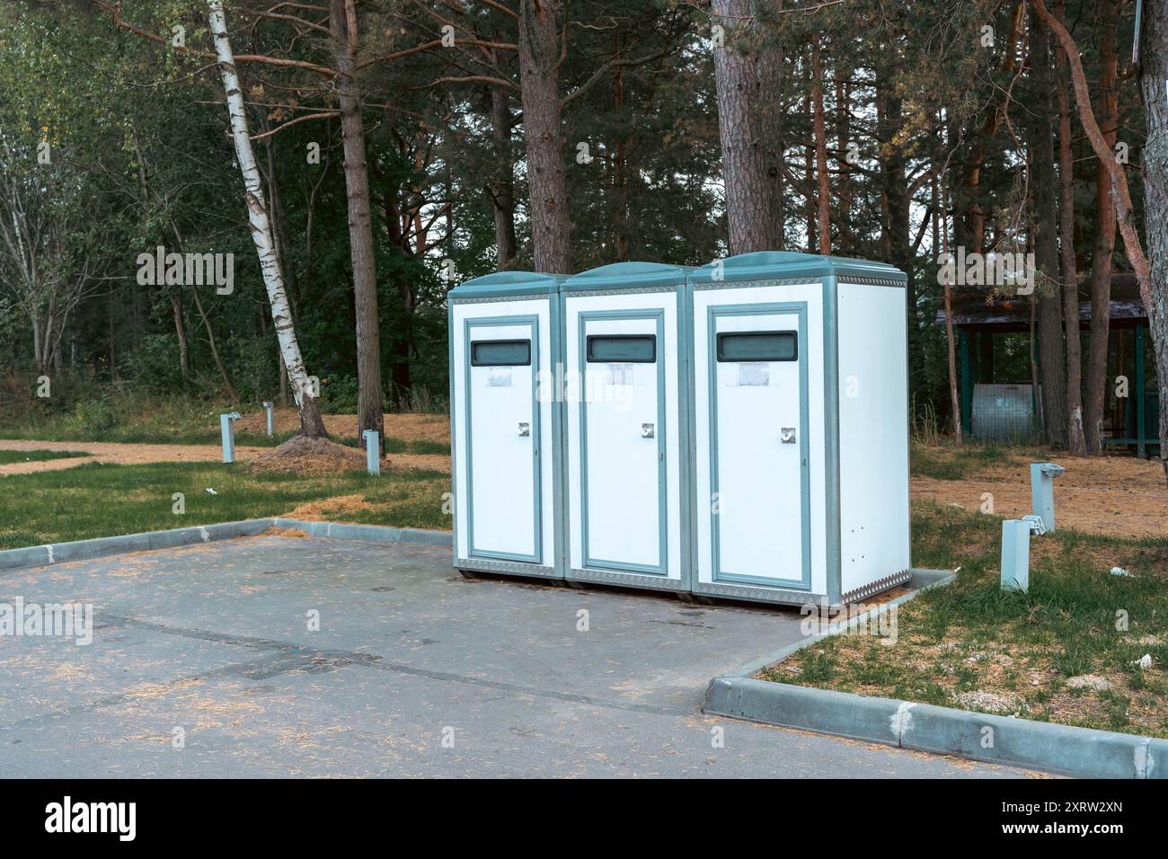 A row of outdoor mobile restroom booths set up in a park, perfect for ...
