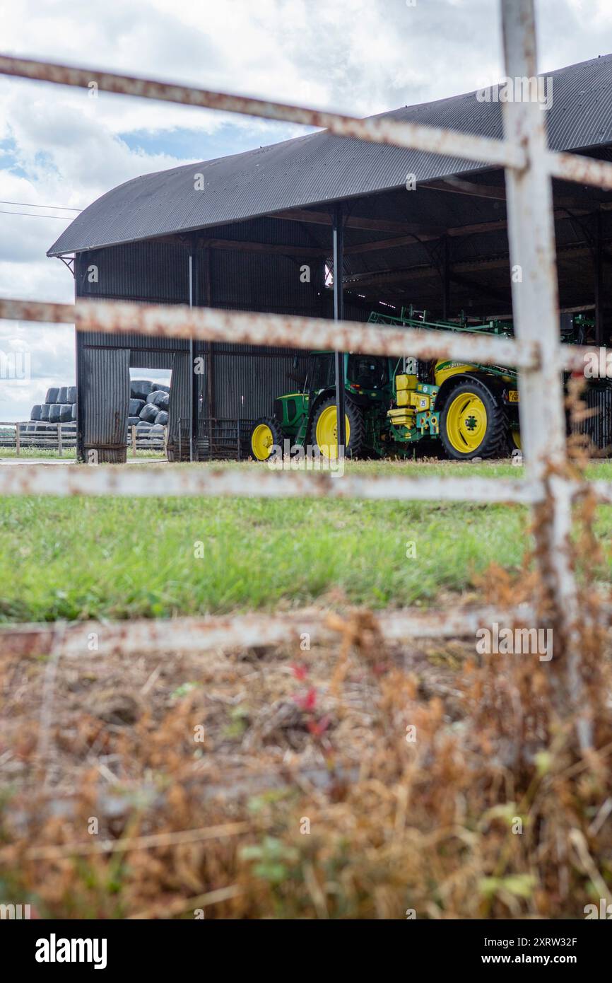 An old tractor stored in a half open barn on a farm in the UK Stock ...