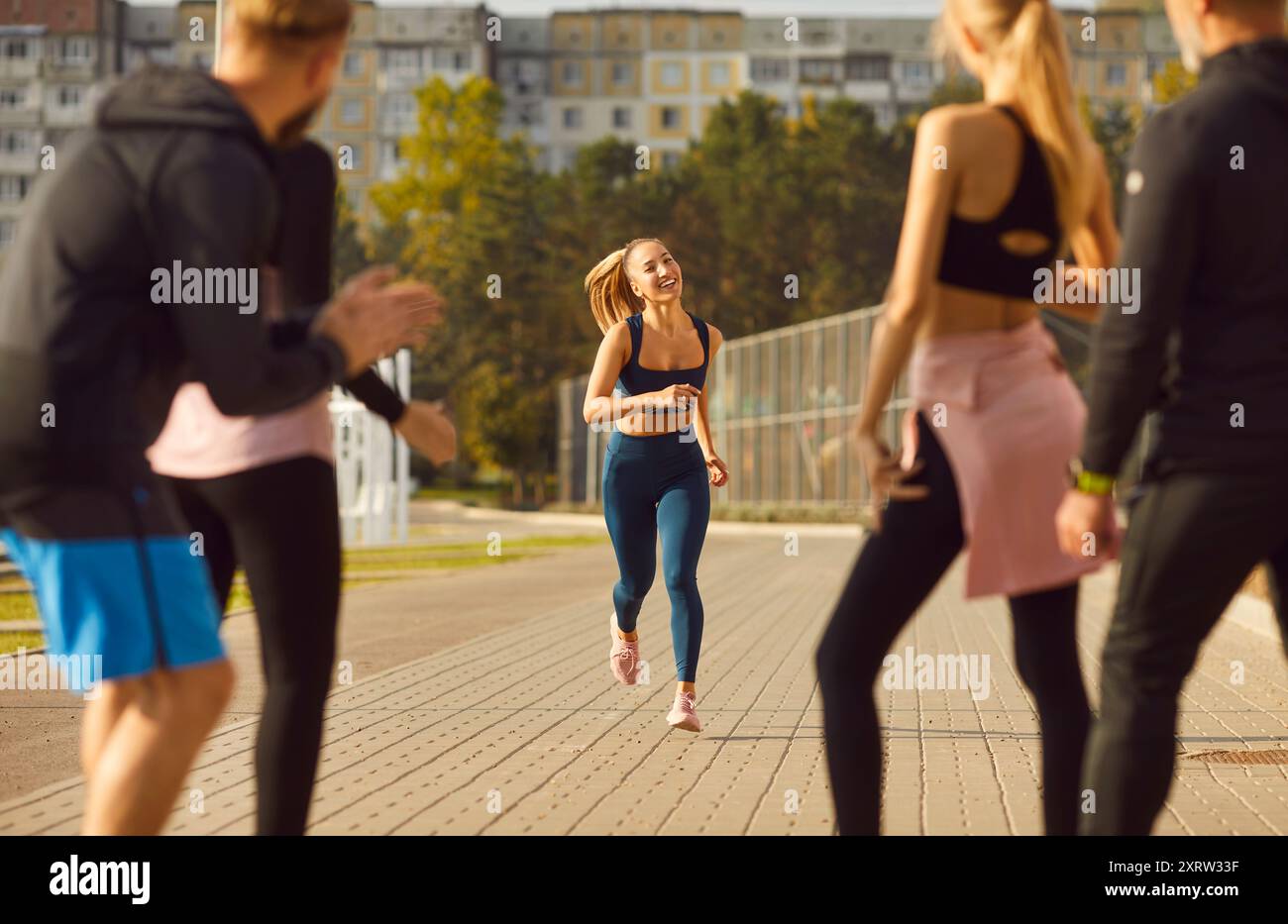 Running, friends waiting for female athlete, happy diverse people ...