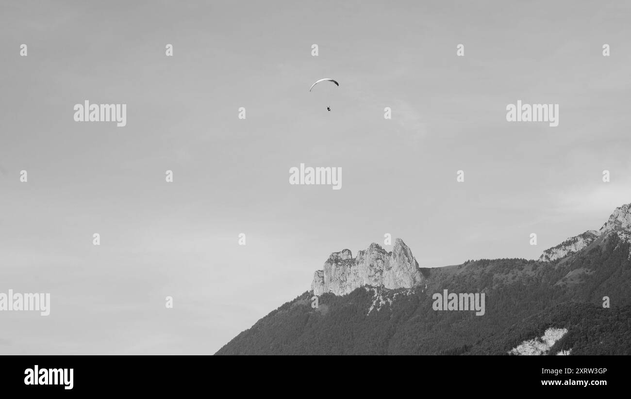 Paraglider flying over the mountains of Savoy at Annecy Lake (France ...