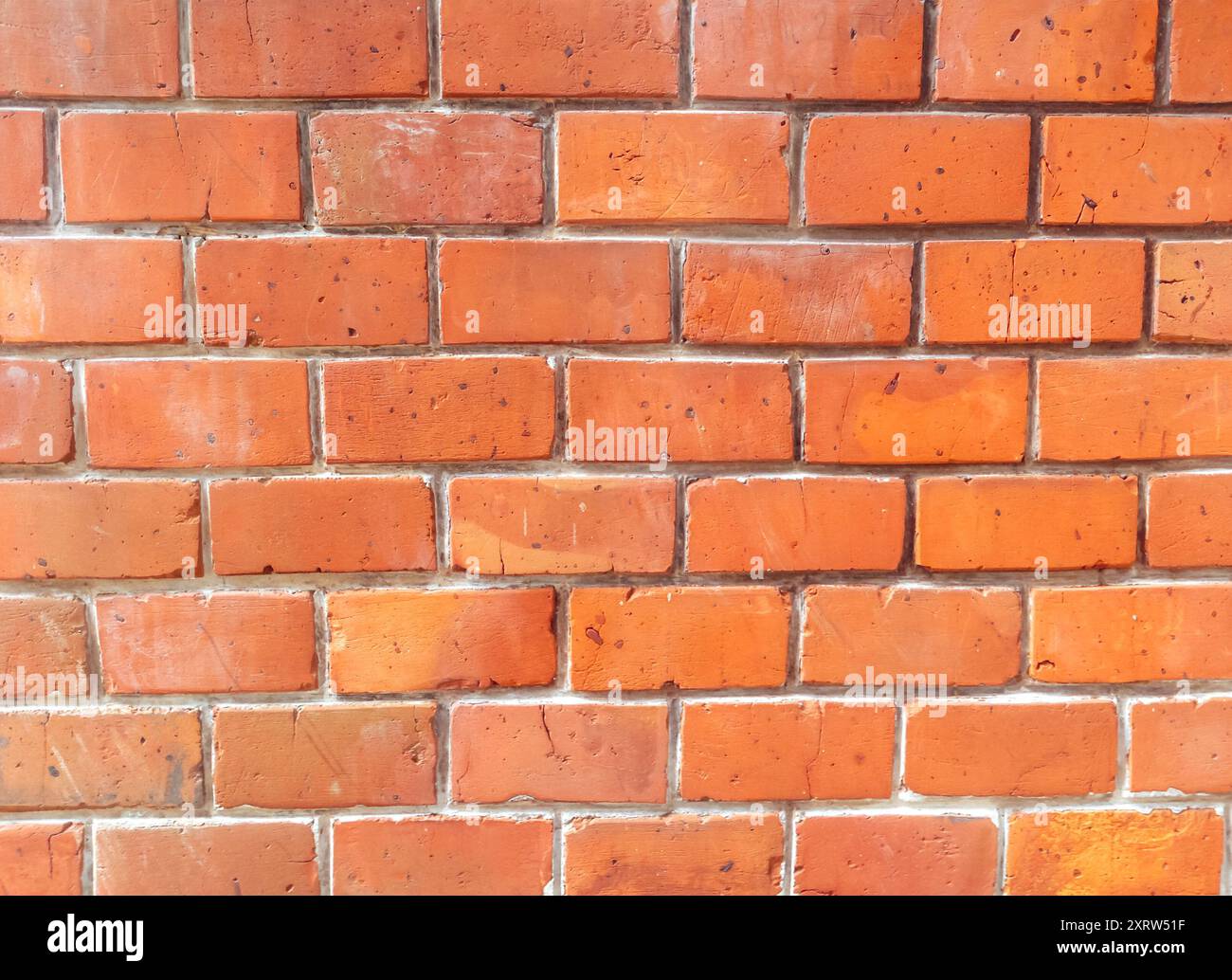 A brick wall with a red brick color. The wall is made of bricks and has ...