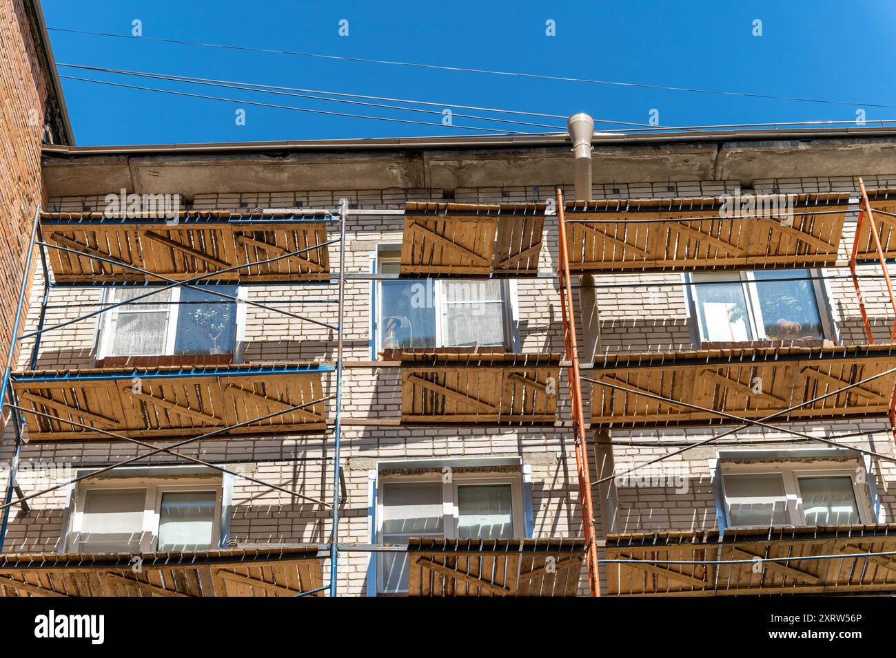 Scaffolding covers windows on a brick building under renovation Stock ...