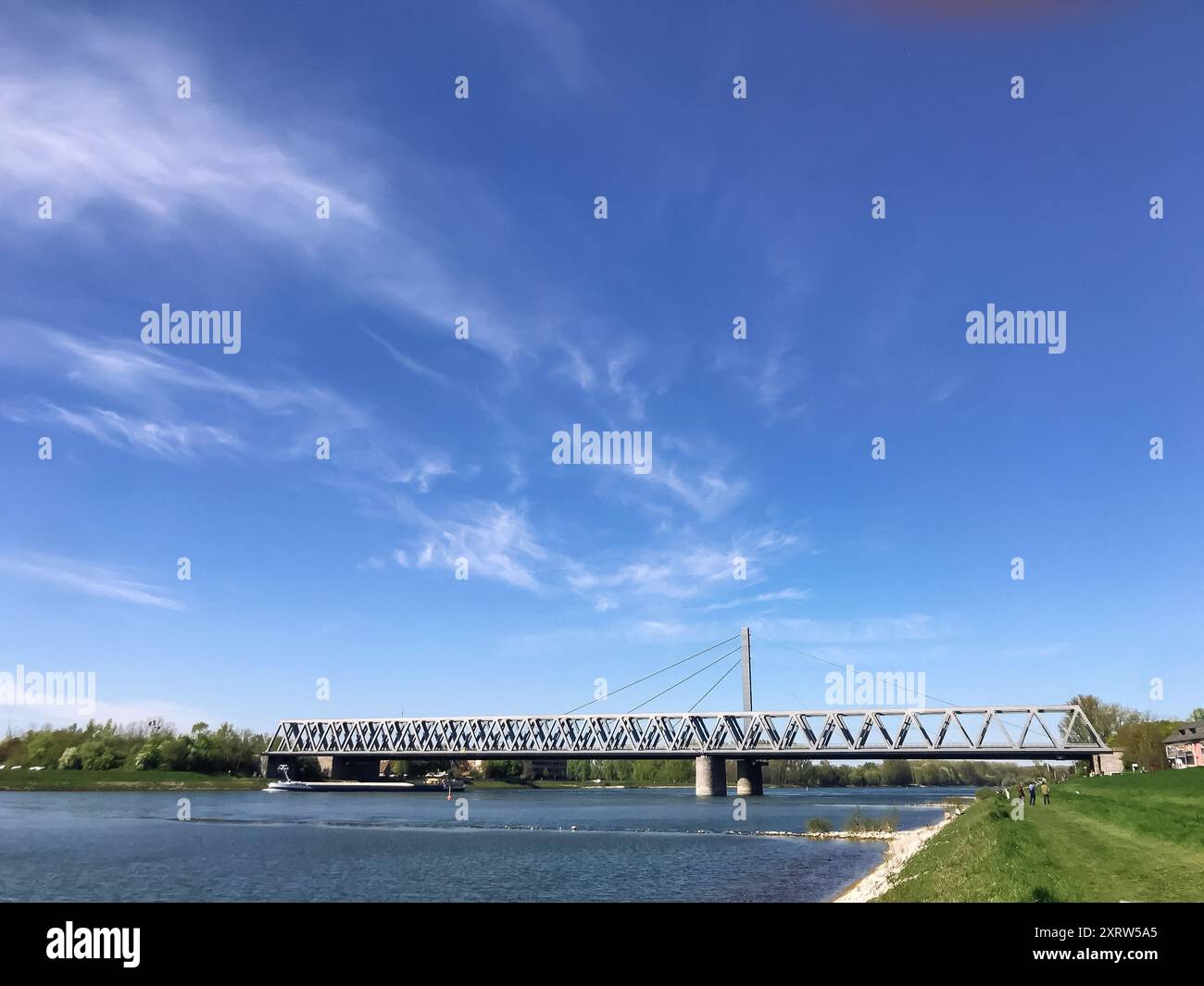 A bridge spans a river with a clear blue sky above. The bridge is a ...