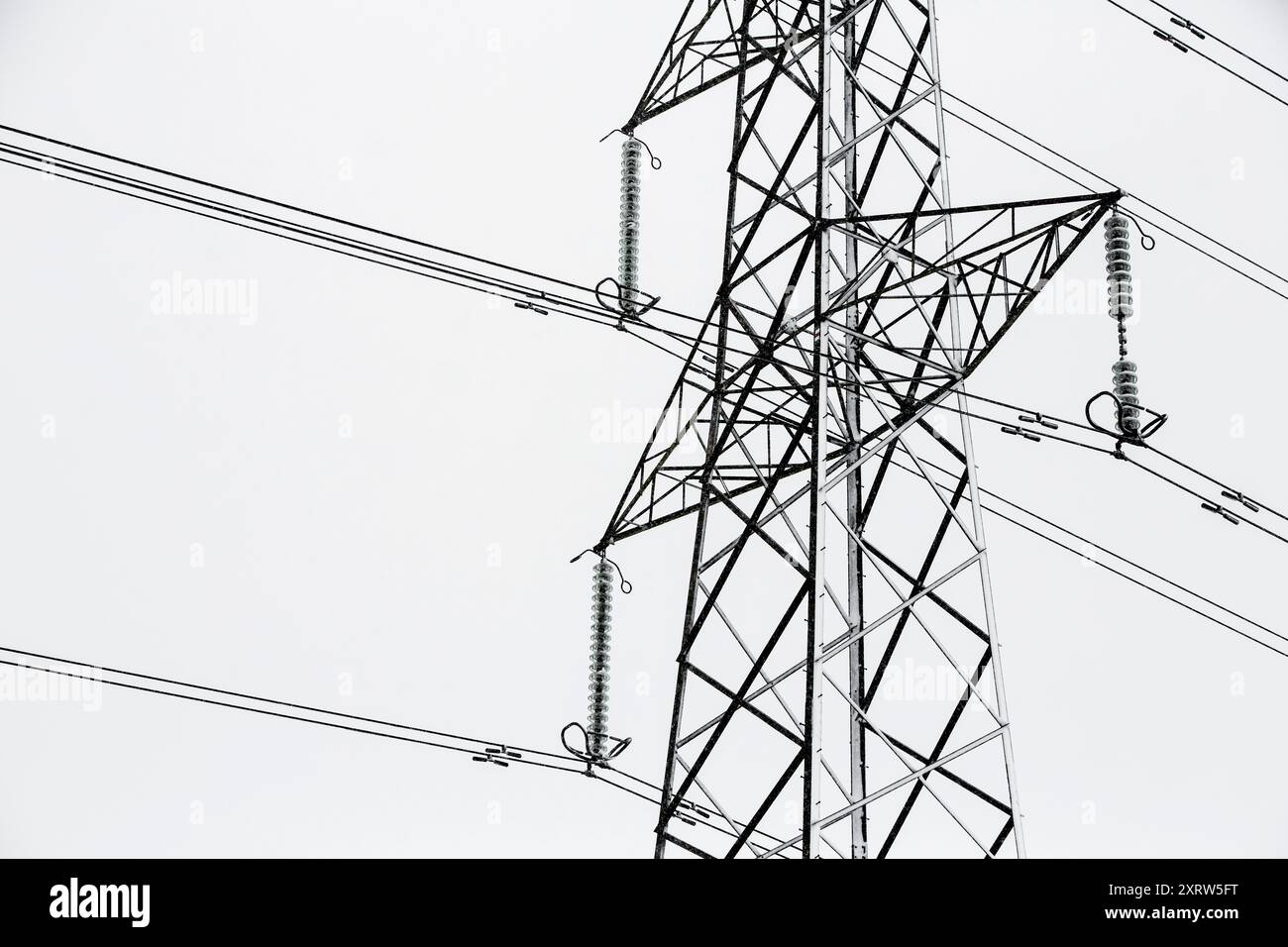 Looking up at a pylon carrying electrial wire and coverd in layer of ...