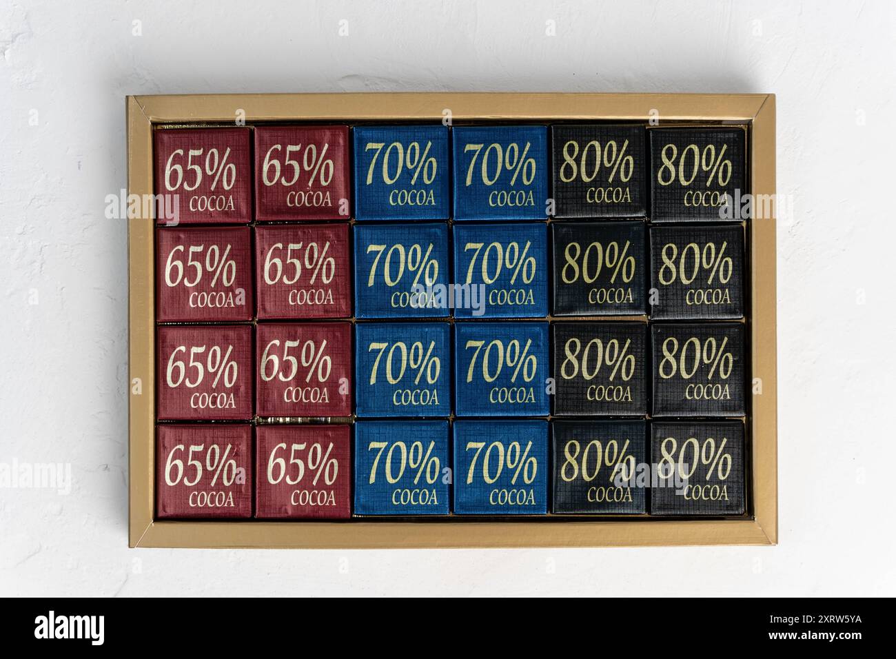 Chocolate squares in gold box, labeled with cocoa content Stock Photo ...