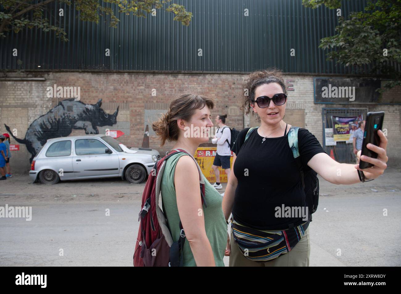 London, UK. 12 Aug 2024. People pose for photos with Street Artist ...