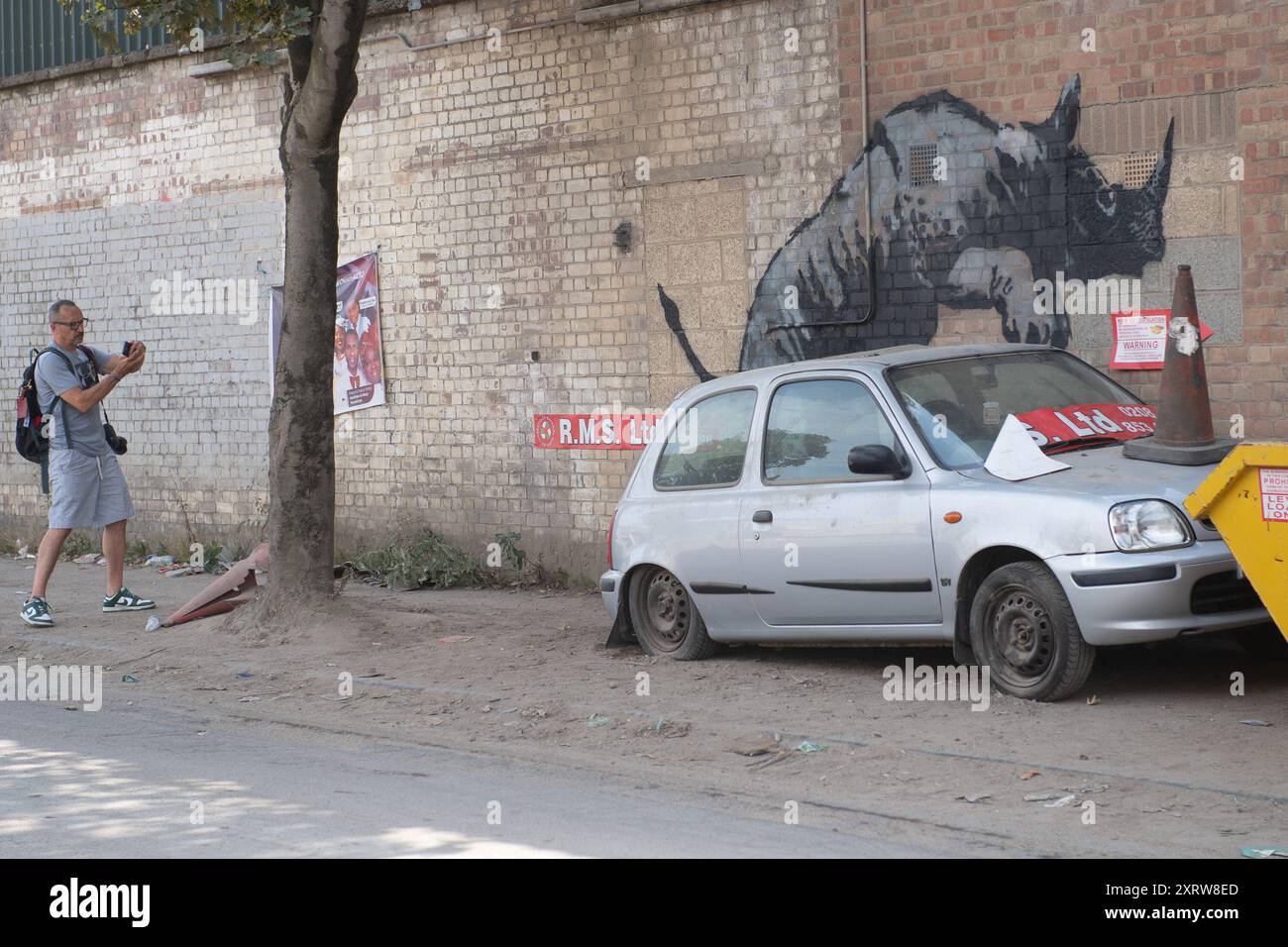 London, UK. 12 Aug 2024. People pose for photos with Street Artist ...