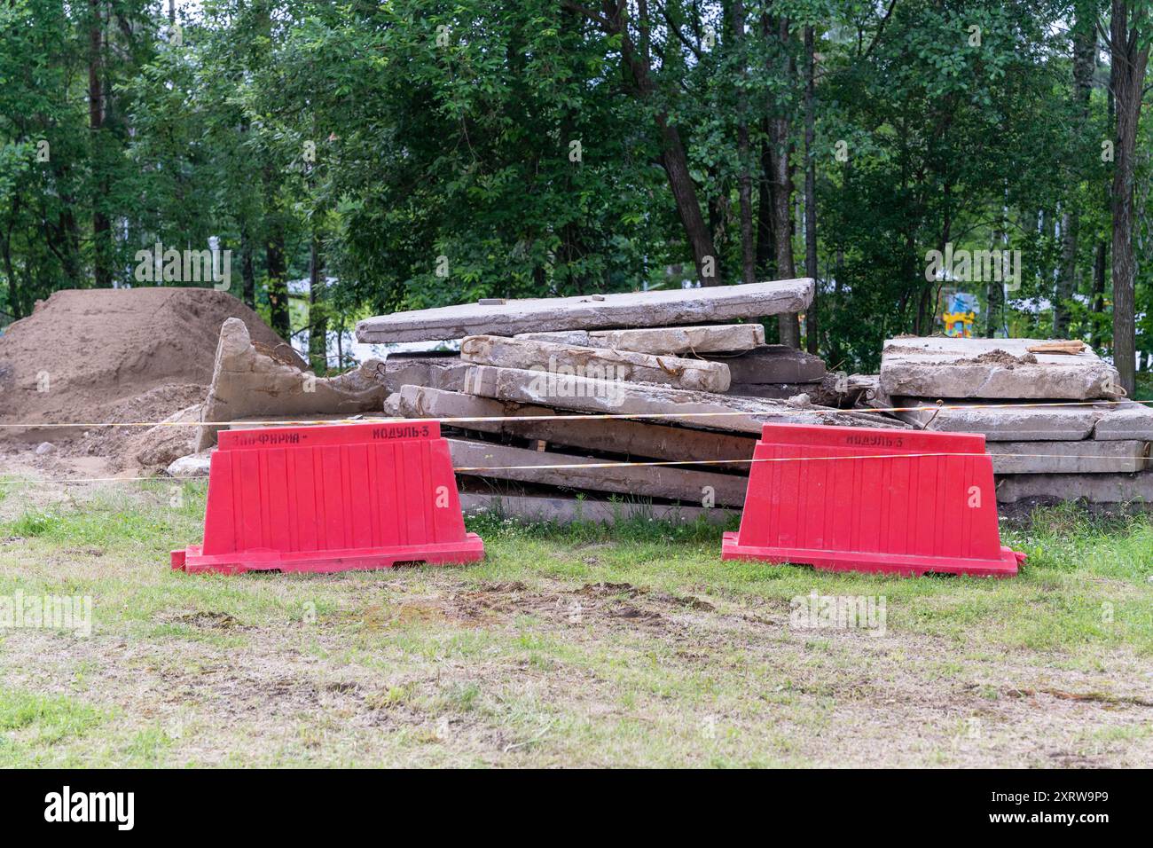 Red barriers in front of concrete slabs in a grassy area Stock Photo ...