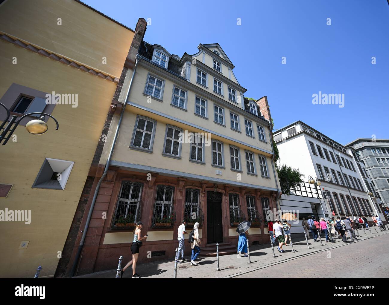 PRODUCTION - 12 August 2024, Hesse, Frankfurt/Main: Tourists walk past ...