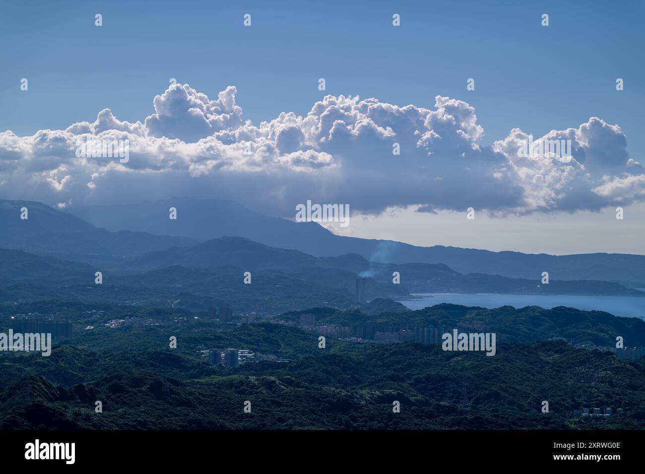 Smoke gently rises from a chimney into the blue sky with rolling white ...