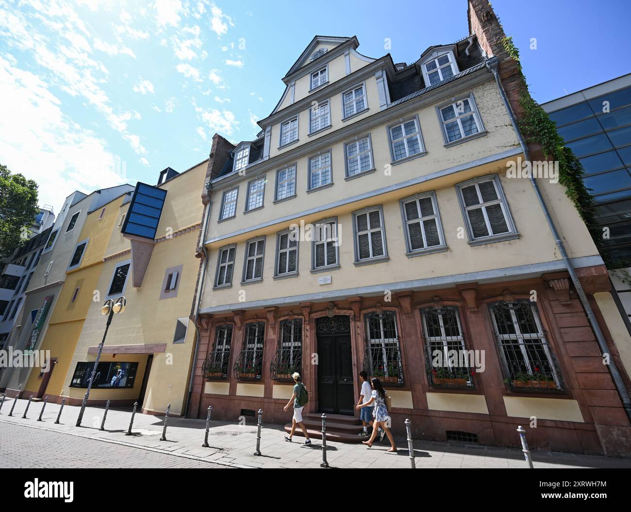 PRODUCTION - 12 August 2024, Hesse, Frankfurt/Main: Tourists walk past ...