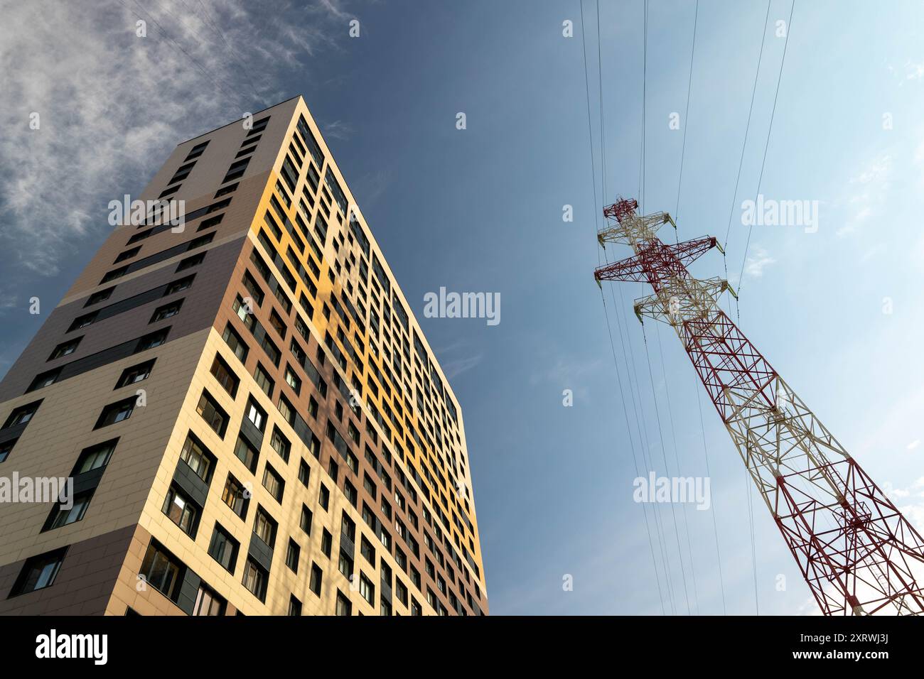 A residential building stands next to a towering communication ...