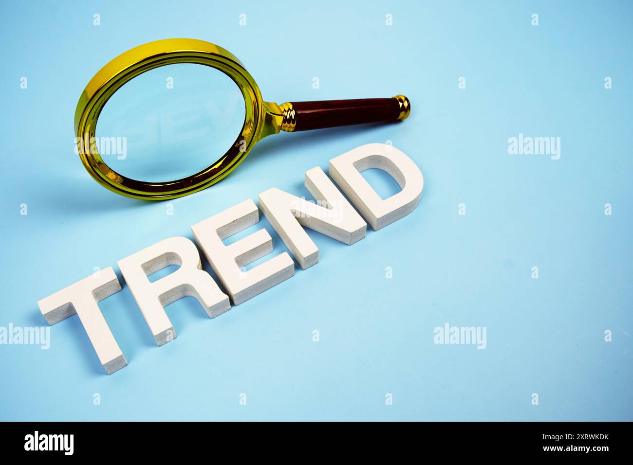 Trend word with magnifying glass top view on blue background Stock ...