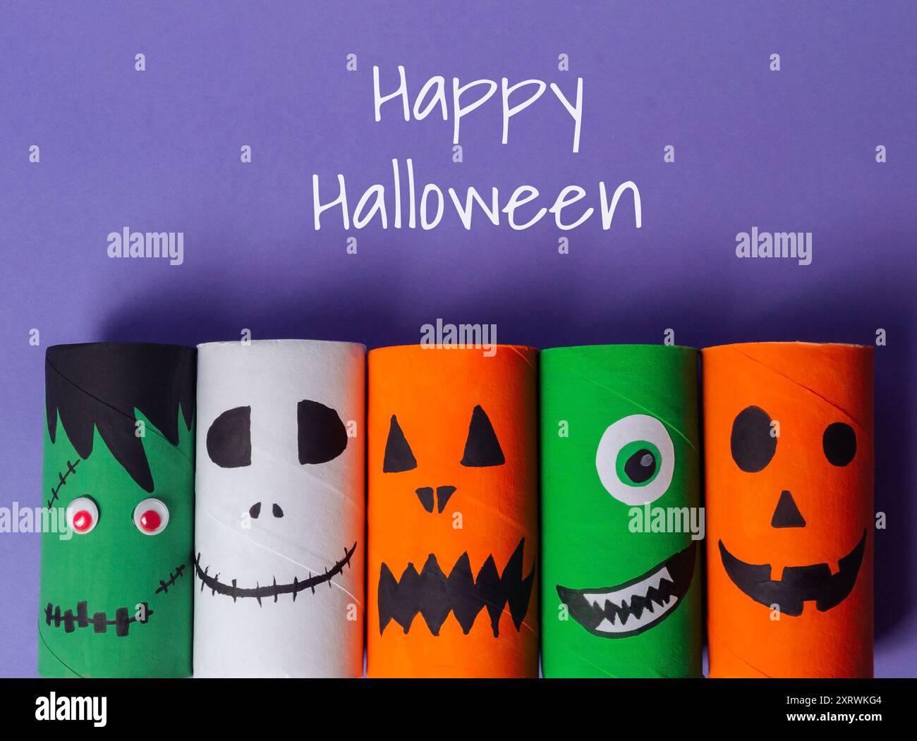 A group of paper tubes with Halloween faces on them. The words "Happy ...