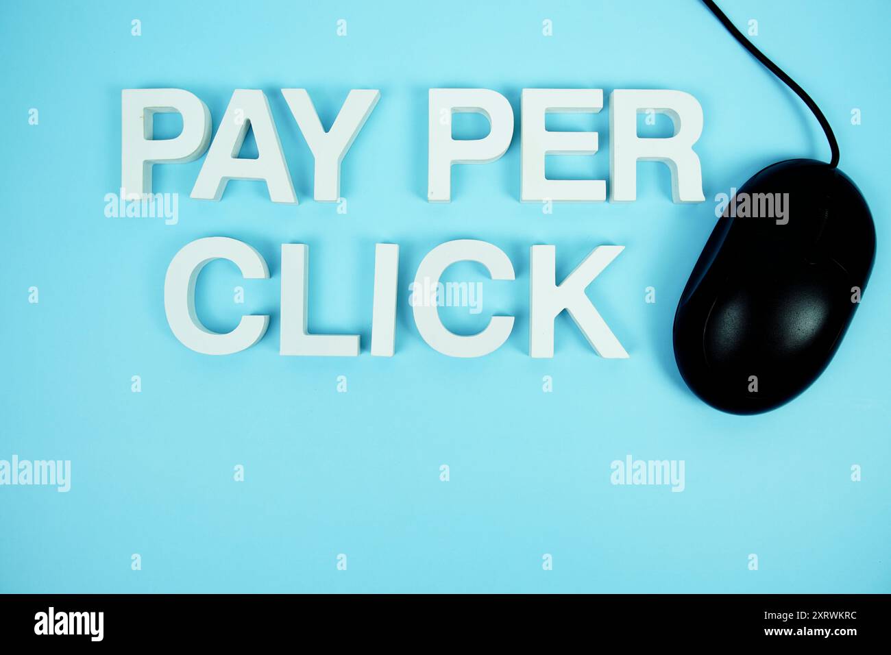 Pay Per Click alphabet letters and optical mouse top view on blue ...
