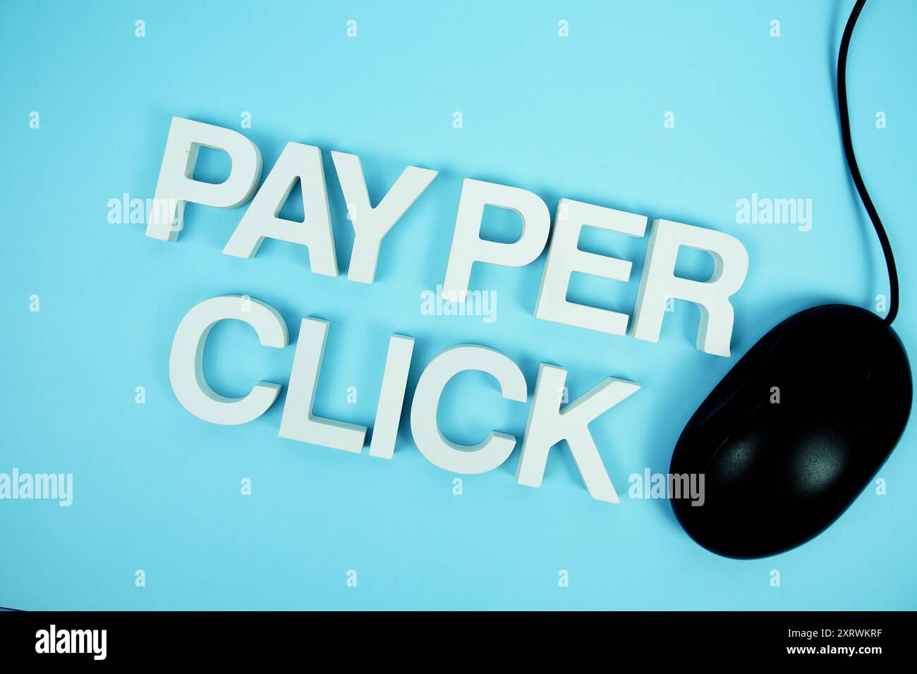 Pay Per Click alphabet letters and optical mouse top view on blue ...