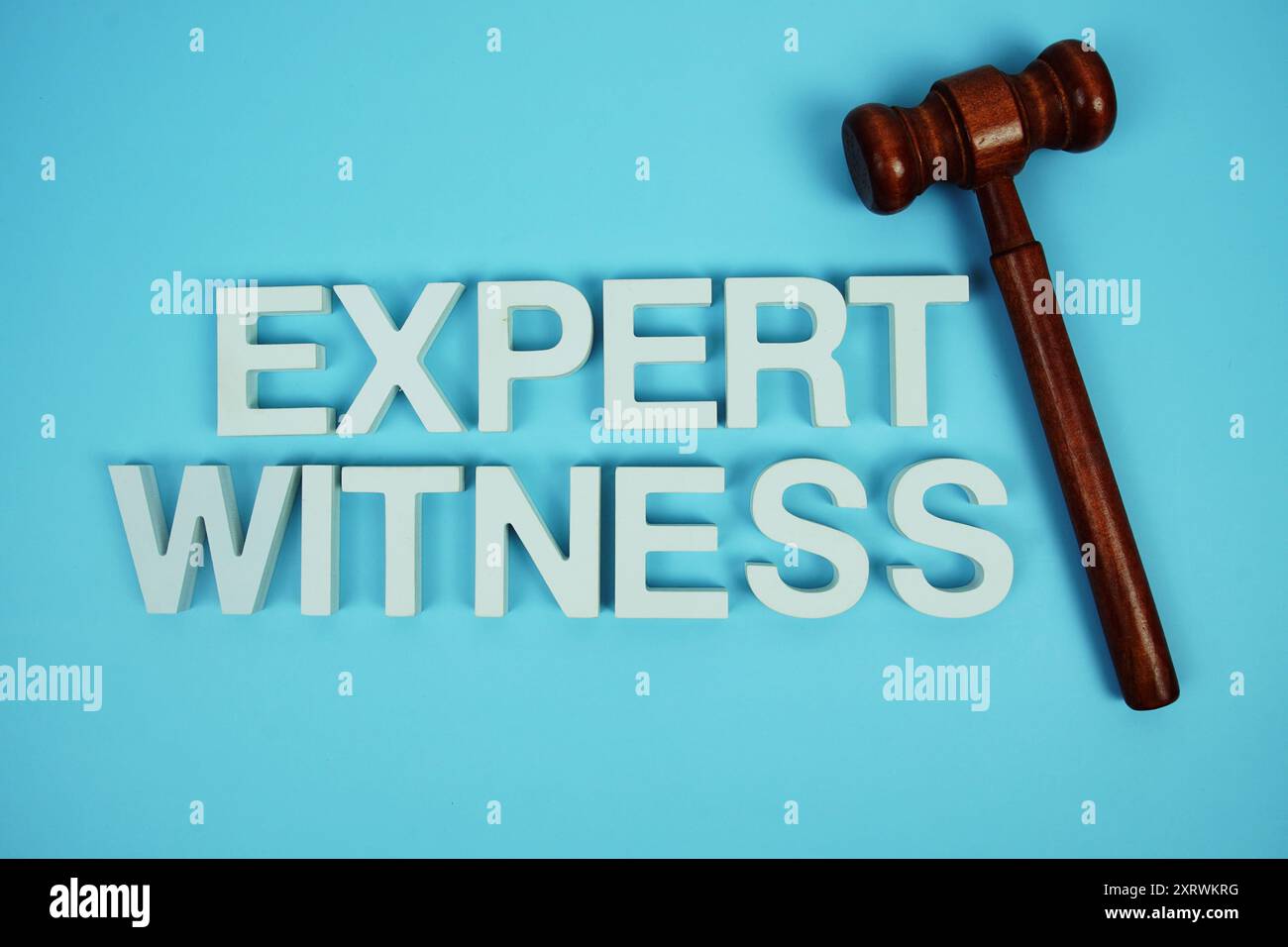 Expert Witness alphabet letters with wooden judge gavel on blue ...
