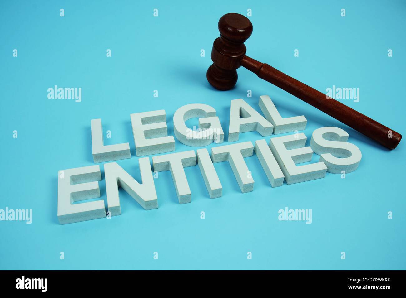 Legal Entities alphabet letters with wooden judge gavel on blue ...