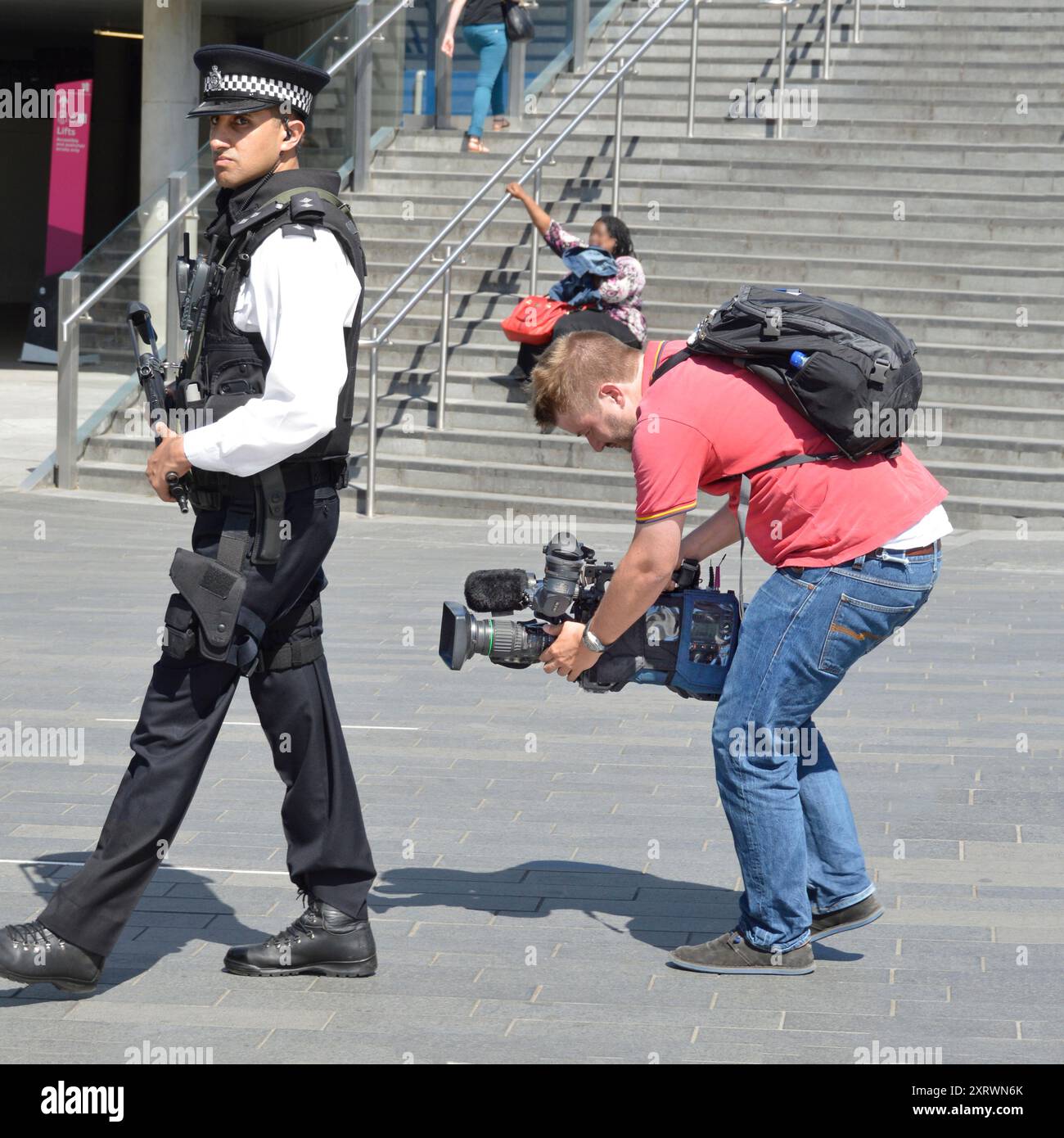 Cameraman with large camera seemingly filming back view close up of ...