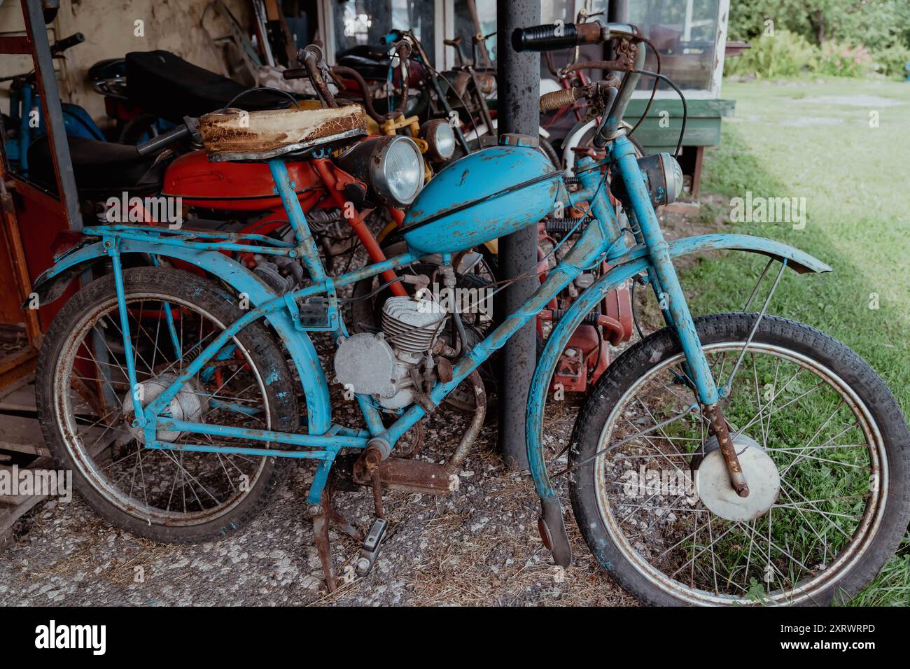 A vintage motorized bicycle is parked in a rustic shed Stock Photo - Alamy