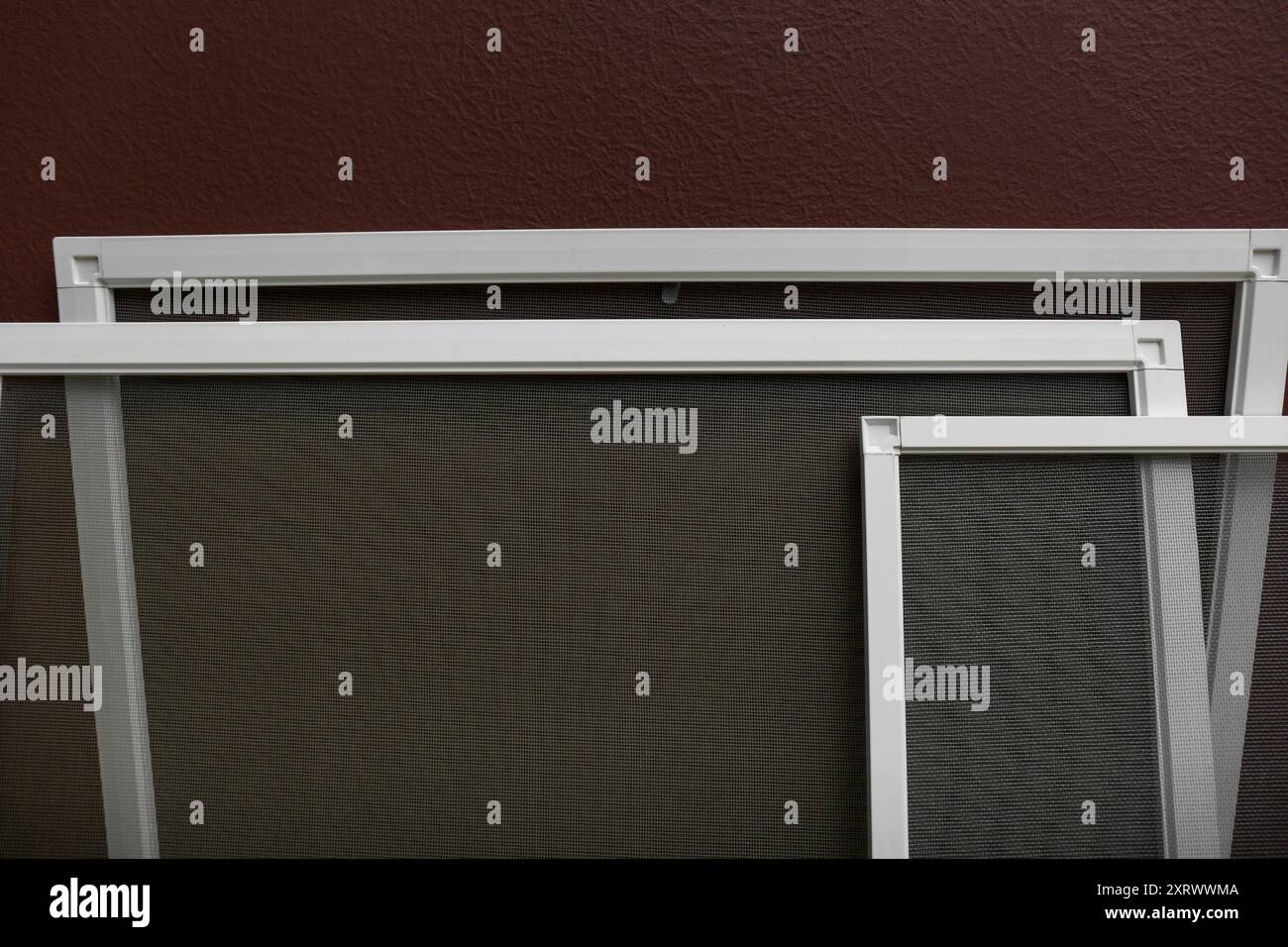 Set of window screens near brown wall Stock Photo - Alamy