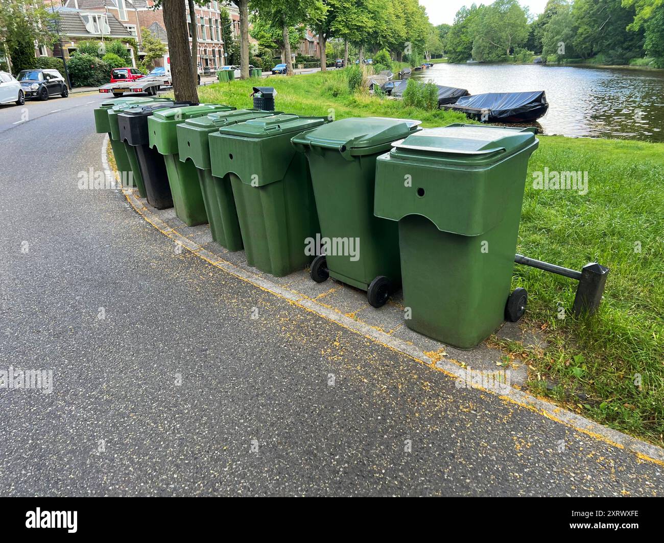 Many green trash bins on city street Stock Photo - Alamy