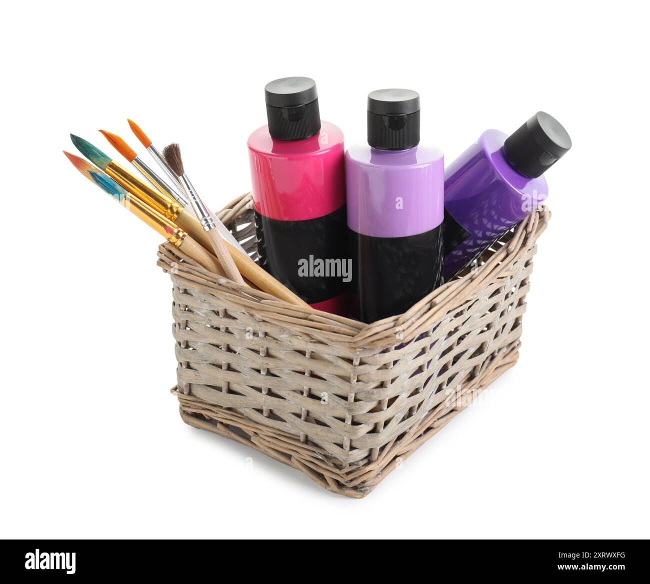 Acrylic paints of different colors and brushes in wicker basket ...