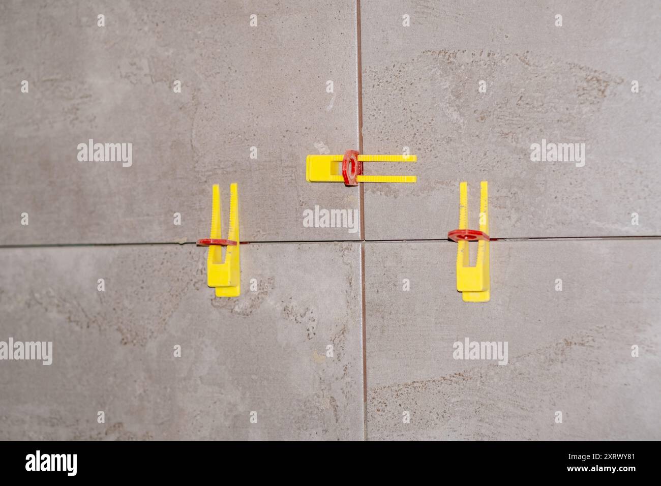 Detailed view of tile leveling system in use with plastic clips and ...