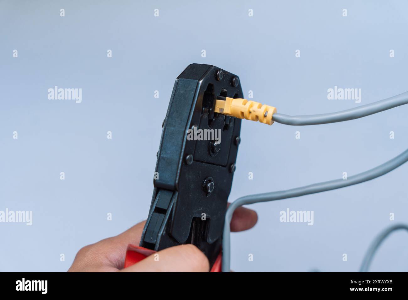 Specialist crimps connector on network cable using crimper Stock Photo ...
