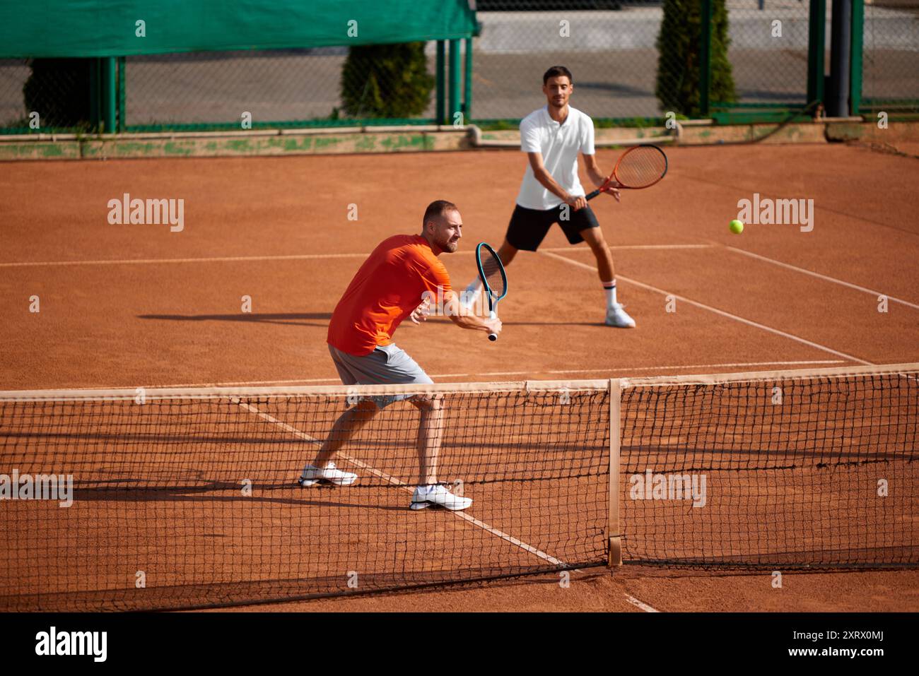 Dynamic image of two men, professional tennis players in motion on clay ...