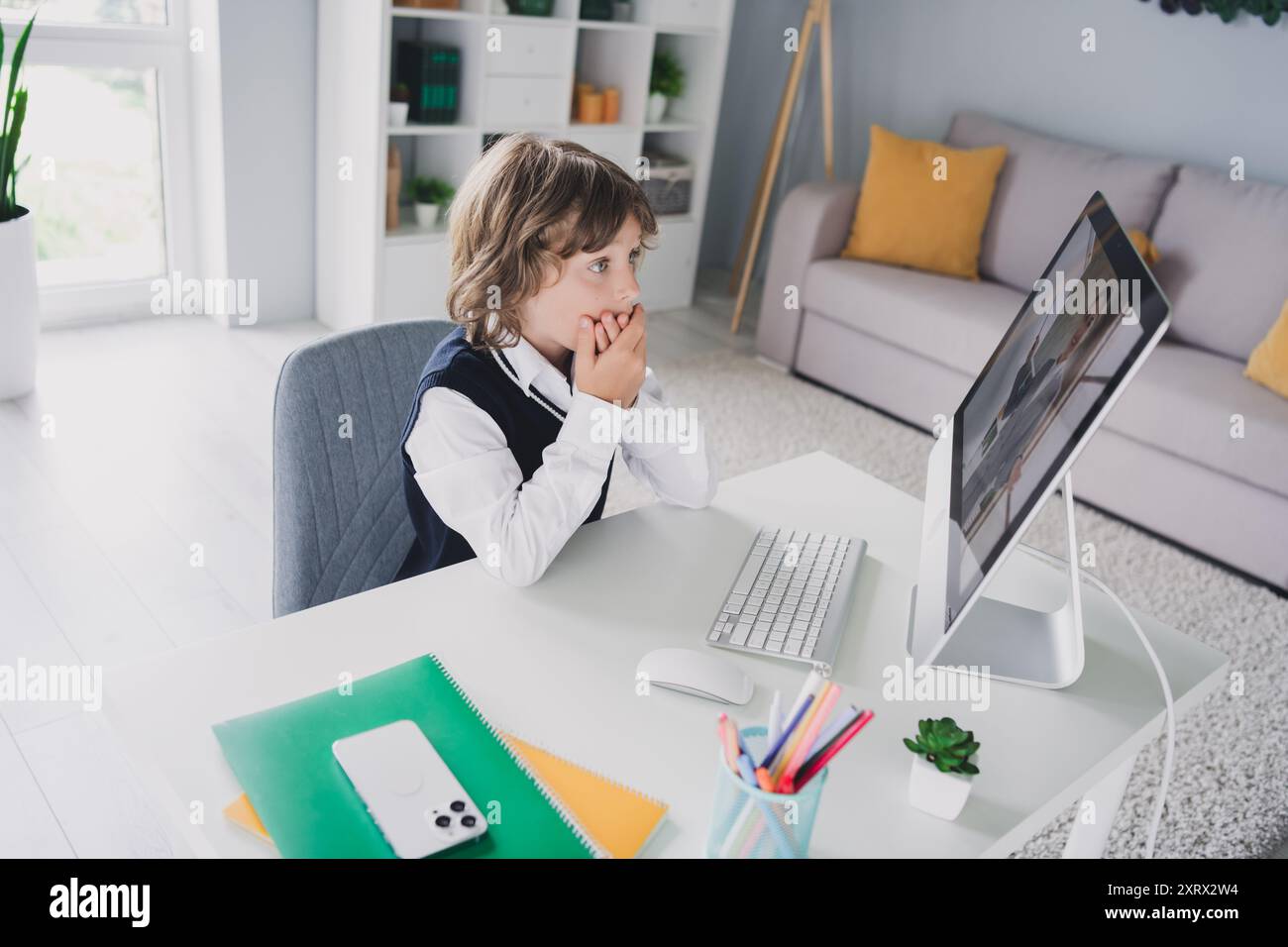 Portrait of shocked charming learner boy sitting chair desk listen ...