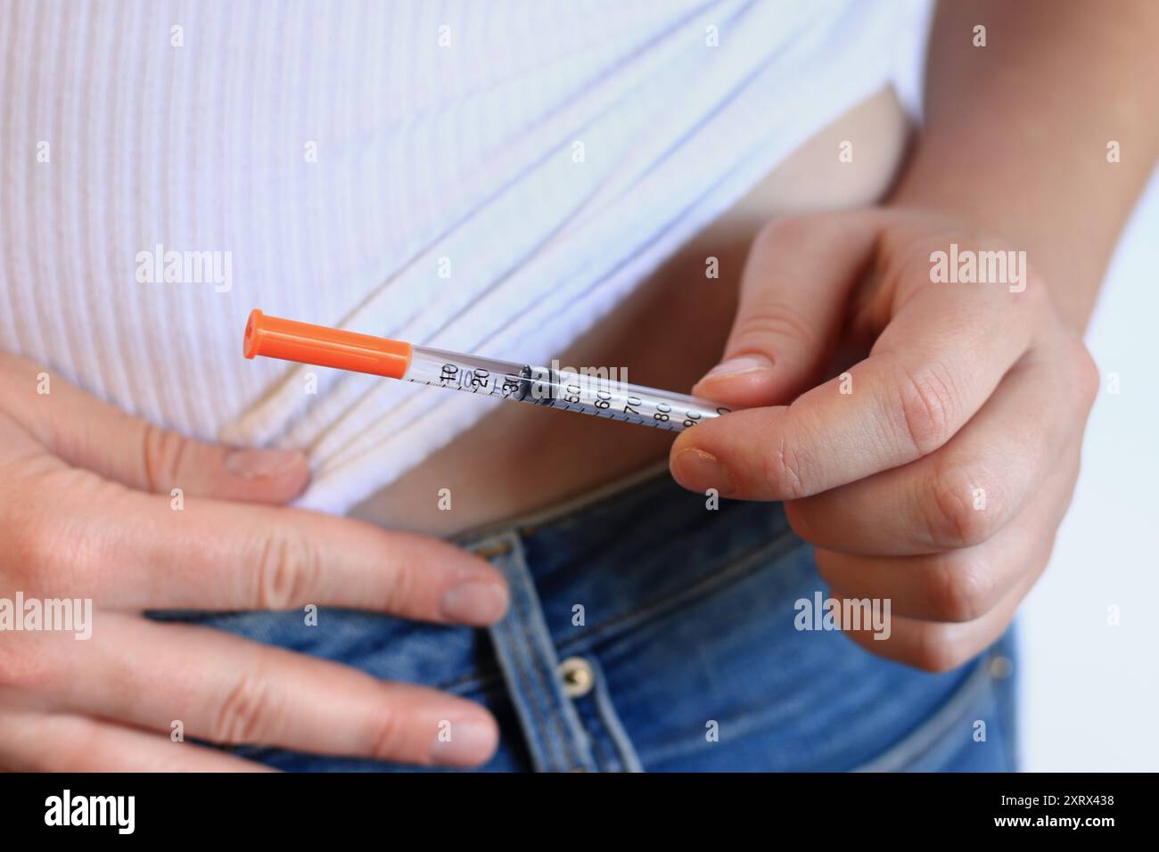 Insulin syringe. A woman with a syringe is about to inject herself with ...