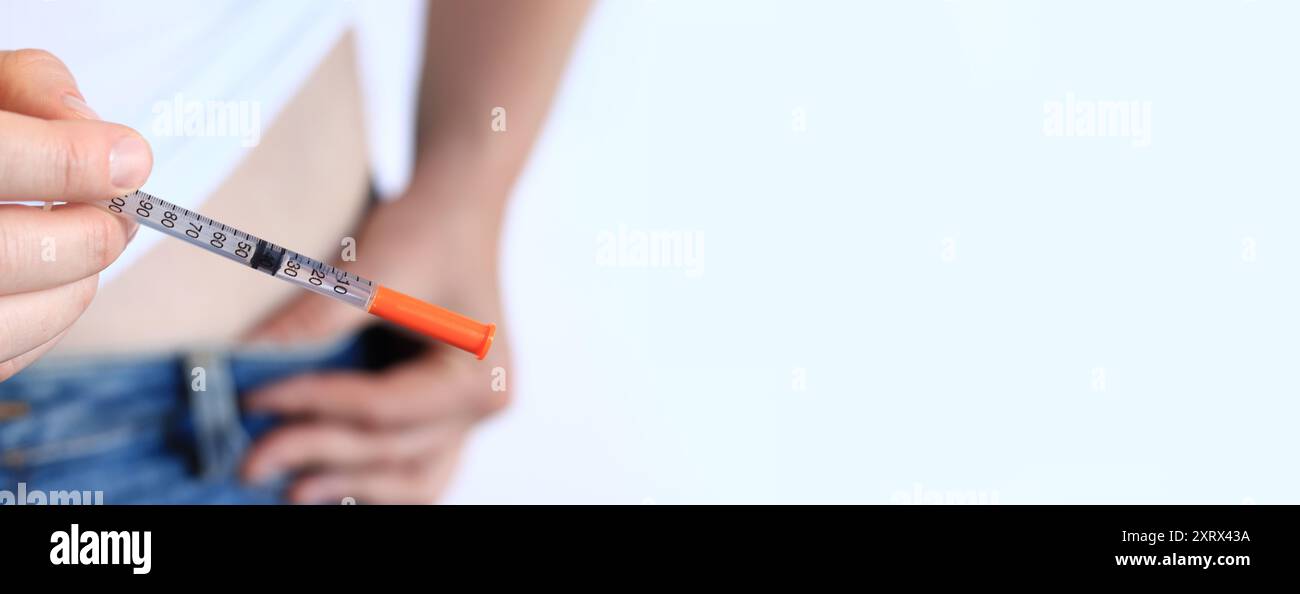 Insulin syringe. A woman with a syringe is about to inject herself with ...