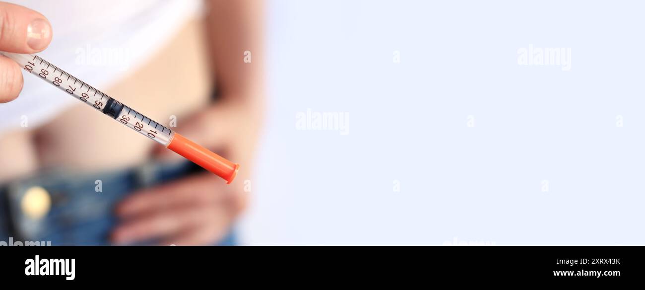 Insulin syringe. A woman with a syringe is about to inject herself with ...