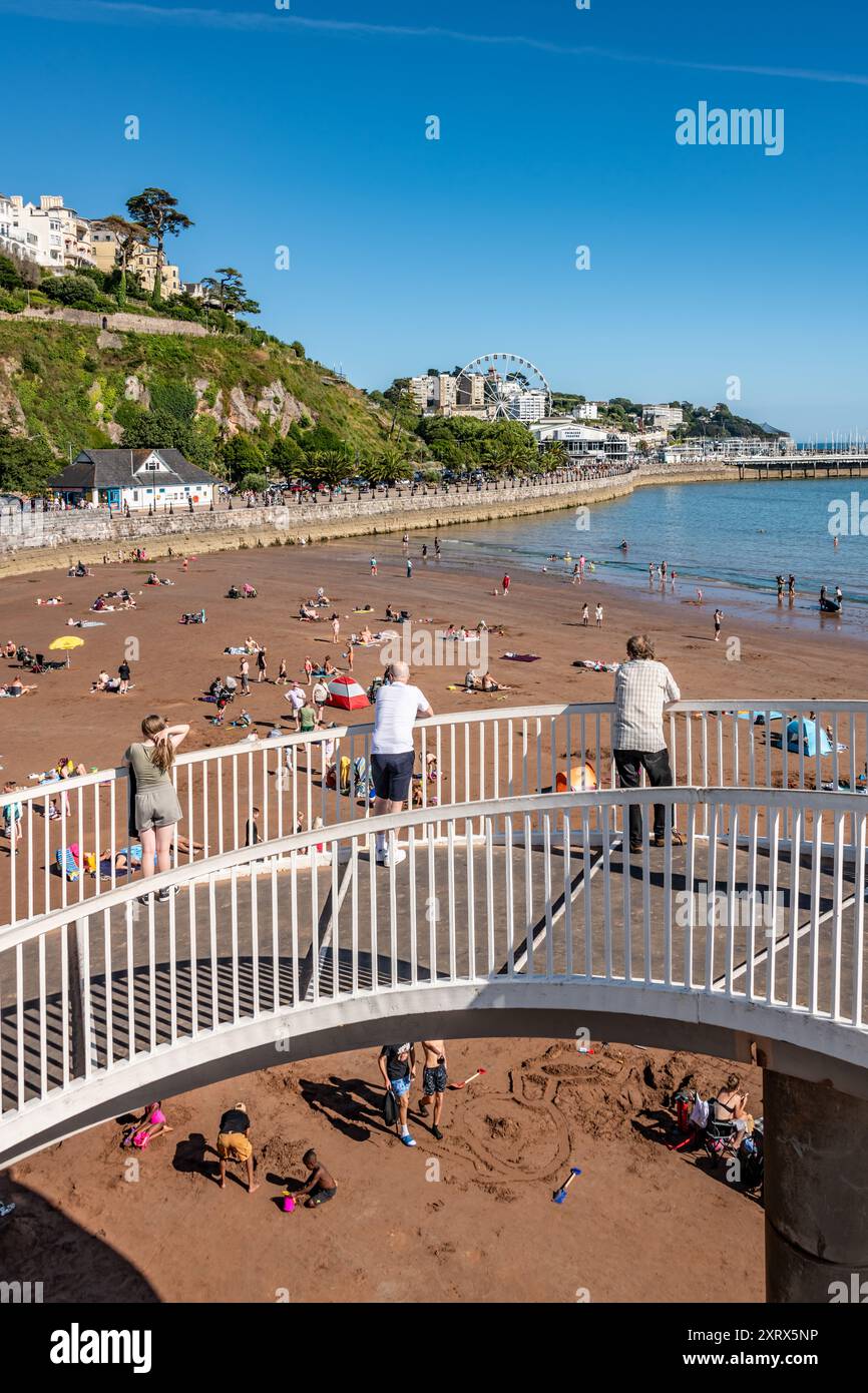 Torquay, UK. 12th Aug, 2024. Beachgoers make the most of the weather on ...