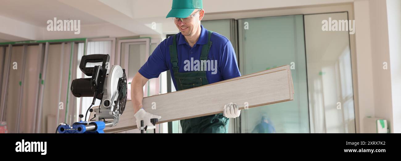 Male carpenter working using special equipment for cutting laminate ...