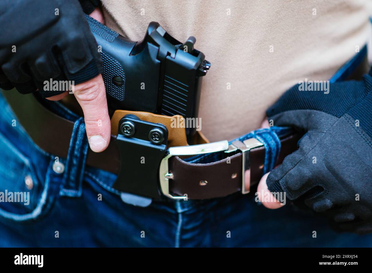 the guy puts the gun in the holster Stock Photo - Alamy
