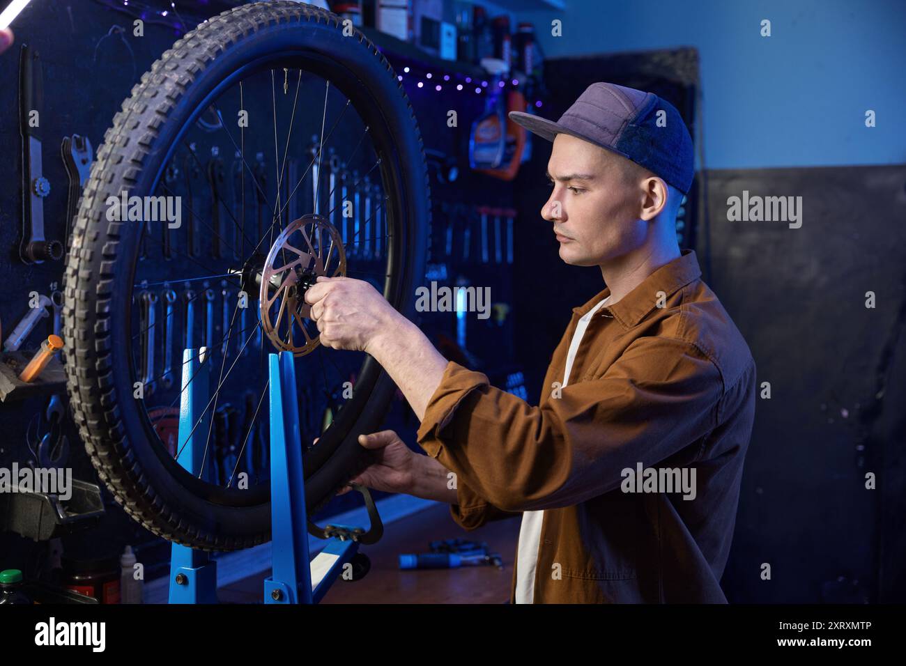 Bicycle mechanic repairing mountain bike wheel at dark workshop Stock ... Bicycle mechanic repairing mountain bike wheel at dark workshop Stock ...