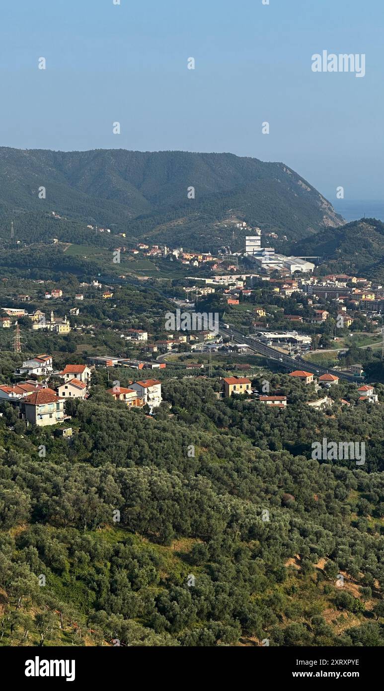 Town in mountains near sea on Ligurian coast of Italy. Houses, olive ...